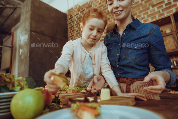 little girl helping mother cooking dinner for family at home Stock ...