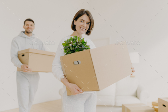 couple enter own modern house, buy real estate, carry cardboard boxes ...