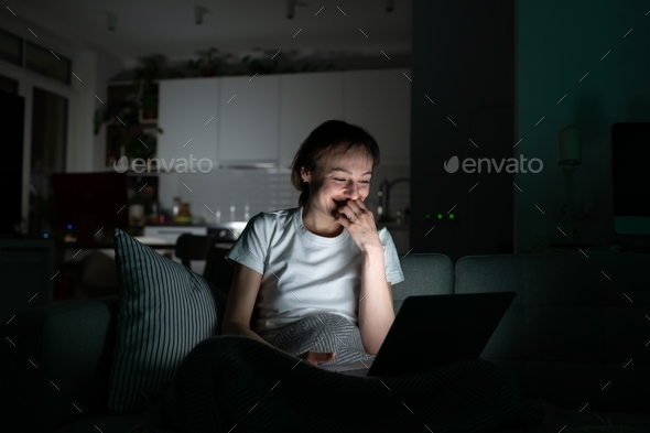 Smiling woman freelancer sitting on couch, working on laptop, talking ...