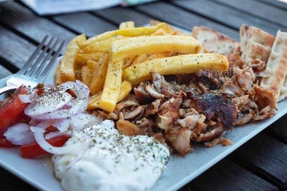Traditional greek dish gyro on white plate, on wooden table Stock Photo ...