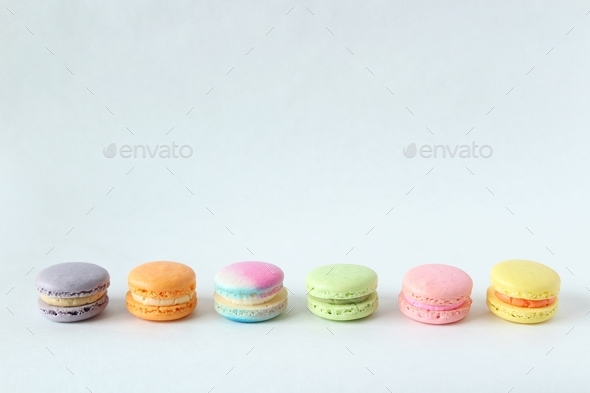 Pastel rainbow colored macaroons against white. Copy space. Stock Photo ...