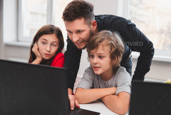 Teacher helping pupils during programming lesson Stock Photo by kegfire