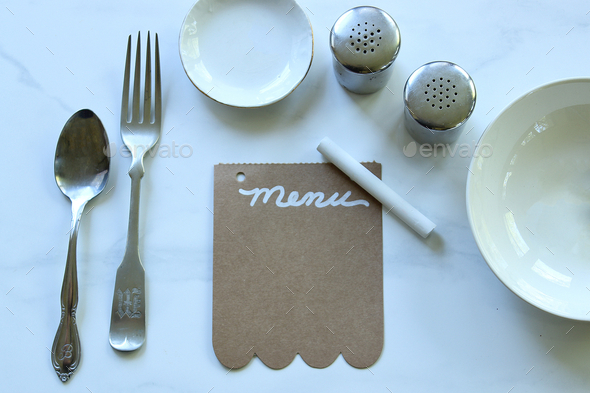 Menu planning concept. Silverware, “menu”, dishes, salt and pepper, and ...