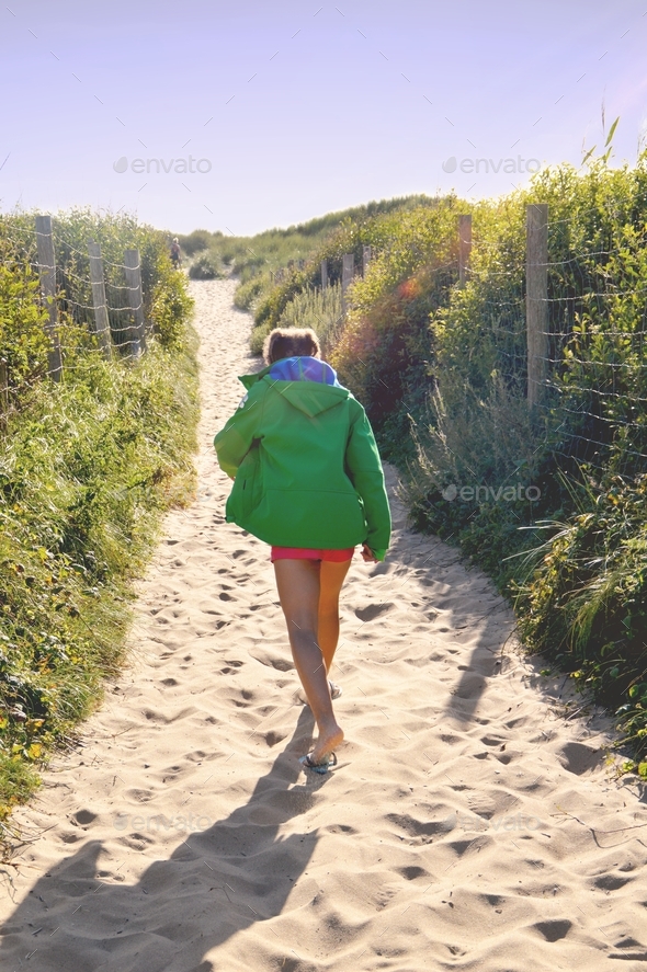 young girl walking in dunes, walking away from camera Stock Photo by ...