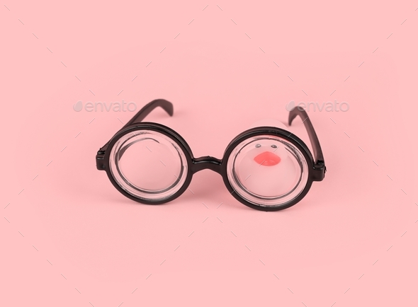 Funny goggles with round glasses on pink background and small rubber ...