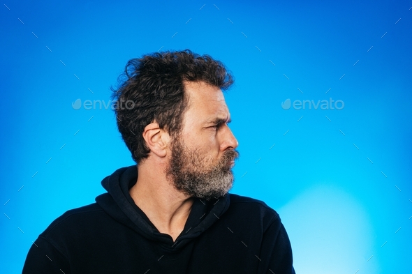 Grumpy old man with beard looking sideway emotions portraits on blue ...