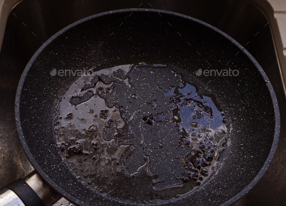 Dirty frying pan with oil, close-up view. Unhealthy eating concept ...