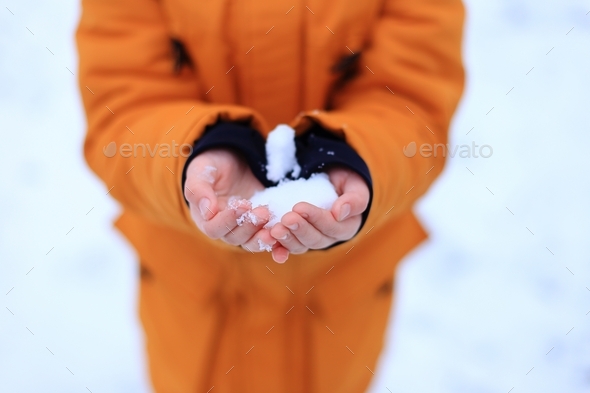 Girl in the forest in winter. Child playing with snow. Snow in hands ...