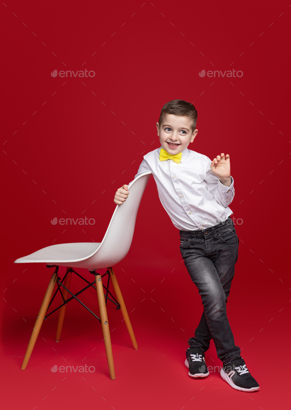 Cute schoolboy standing near chair Stock Photo by kegfire | PhotoDune