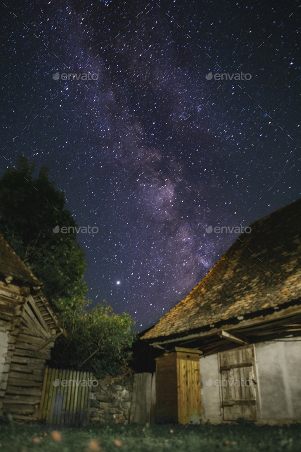 Night sky with Milky Way in the frame and an old barn house in the ...