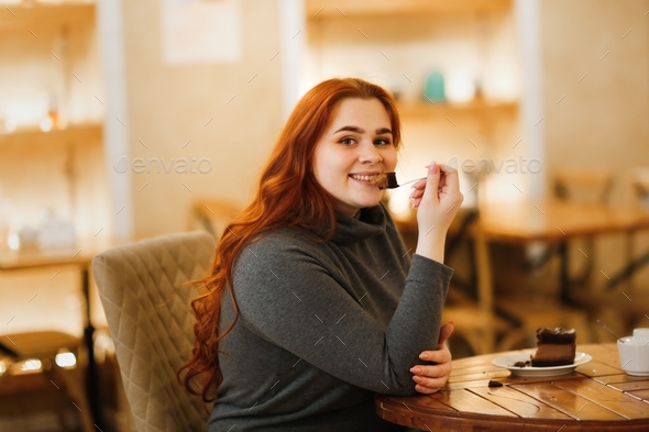 Caucasian beautiful plus size lady overweight woman eating a chocolate ...