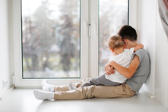 children brothers cuddle on window, relationship of siblings and ...