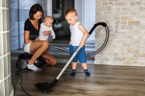 Mom and children are cleaning up,son vacuums floor, Mom and baby ...