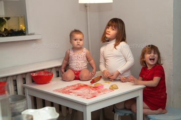 Three sibling children are cooking in the kitchen on the table Stock ...