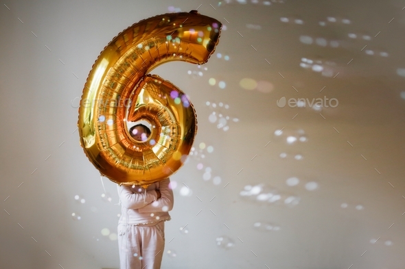Funny emotional child girl hide golden balloon. Stock Photo by ...