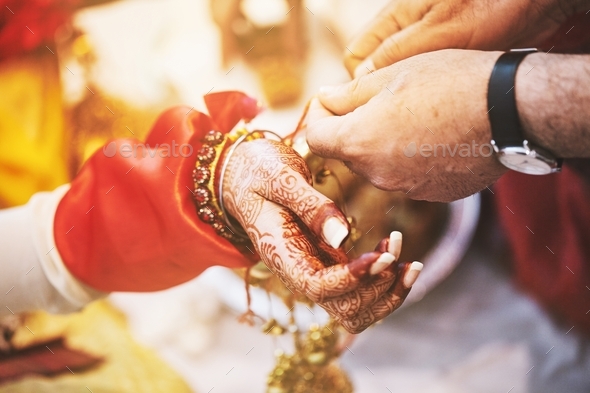 Men ties the holy thread on the wrist of indian bride during puja ...