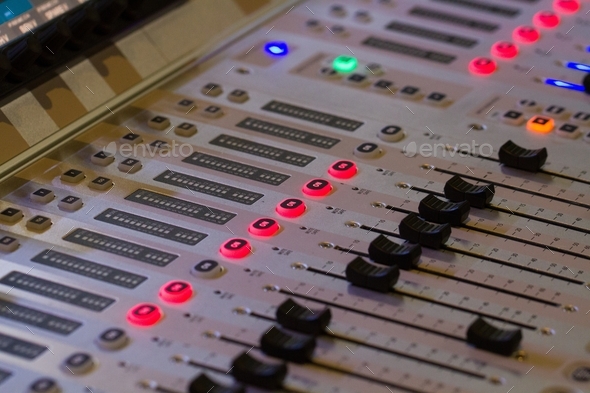 The buttons, sliders and controls of a studio or sound engineers mixing ...