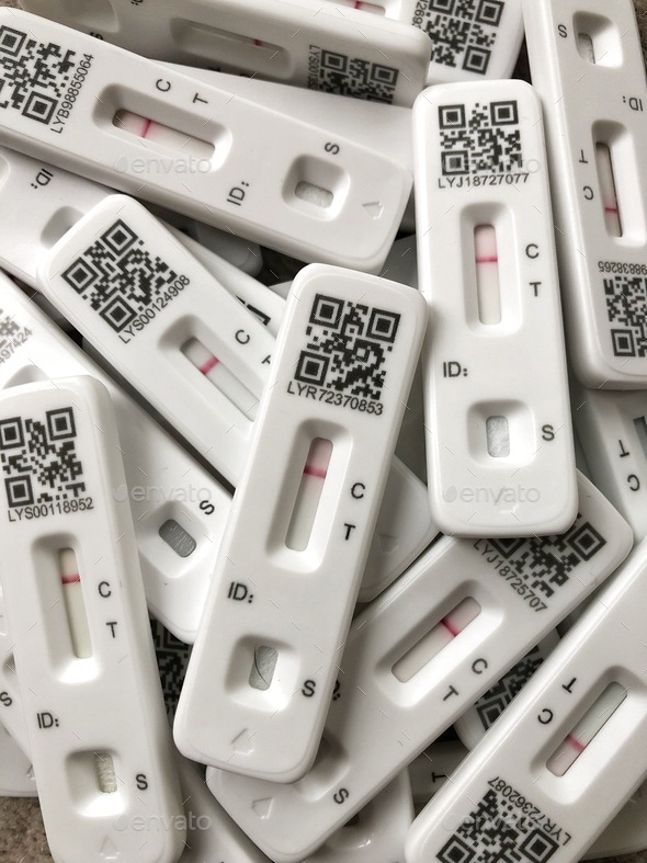 Full frame coronavirus background of a stack of negative home testing ...