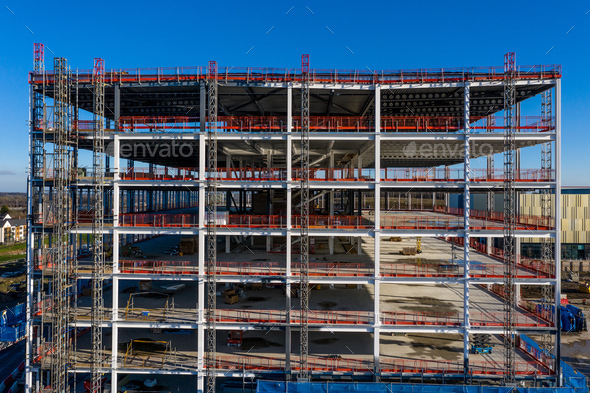 The steel framework of a tall building on a construction site during a ...
