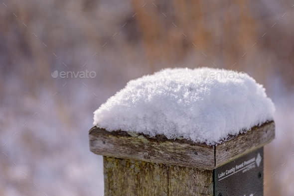 Snow capped post along forest preserve trail in winter Stock Photo by ...