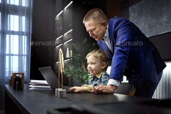 dad businessman at the workplace in the office with his little son ...