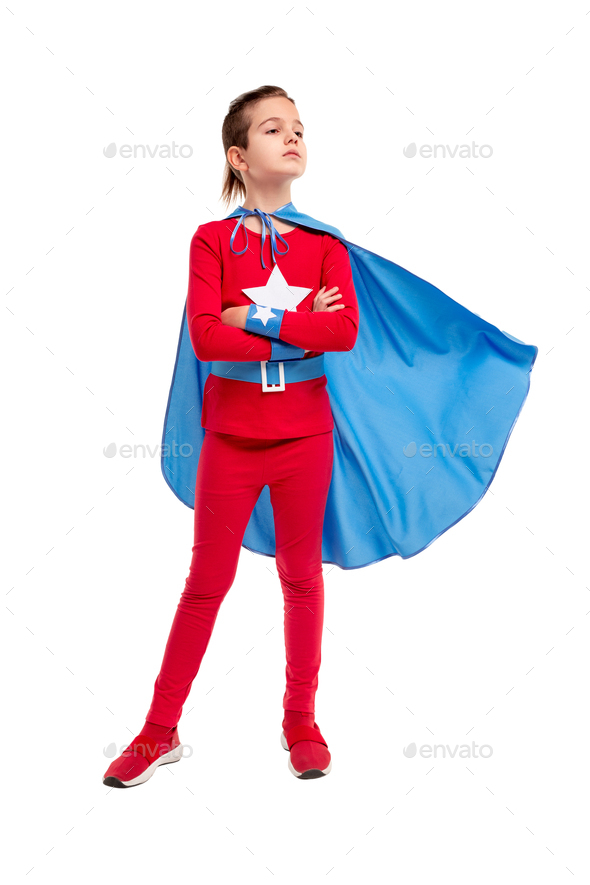 Confident little superhero with fluttering cape Stock Photo by kegfire