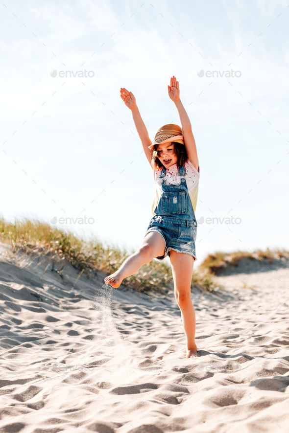 the girl is having fun on the beach, wants to do a somersault Stock ...