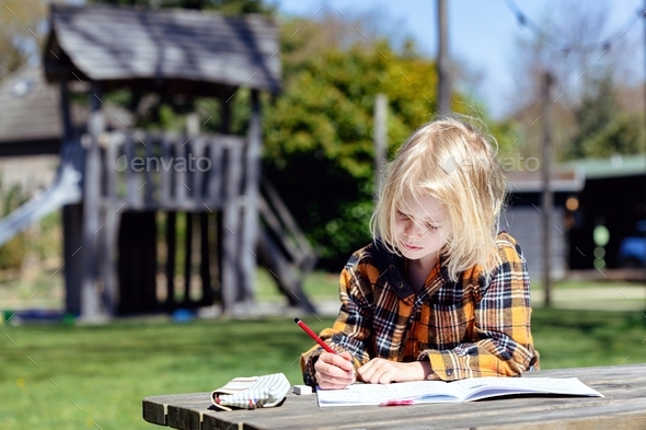 The child is doing homework during outdoor holidays. Stock Photo by ...