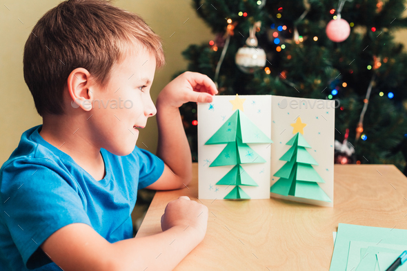 Child making Christmas card from paper. Step 8 Stock Photo by OlgaKhorkova
