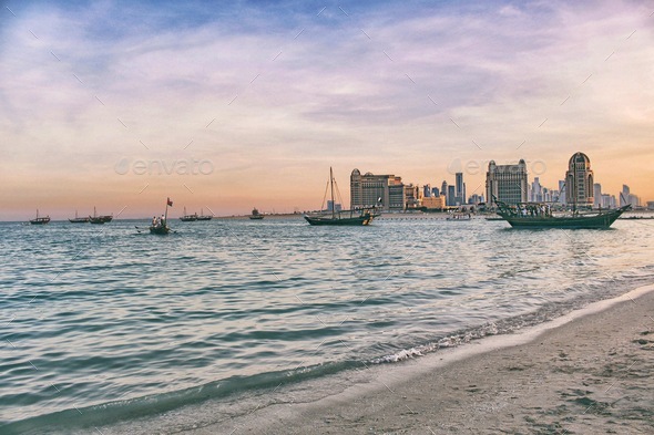 Sunset time at Doha Skyline. Traditional dhow. Ocean. Orange sky ...