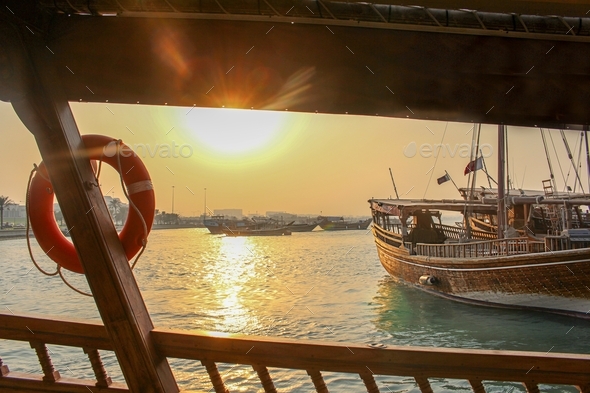 Traditional Wooden dhow boat parked at Doha Dhow port during golden ...