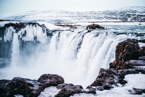 Massive powerful waterfall Iceland winter snow ice cold barren nature ...