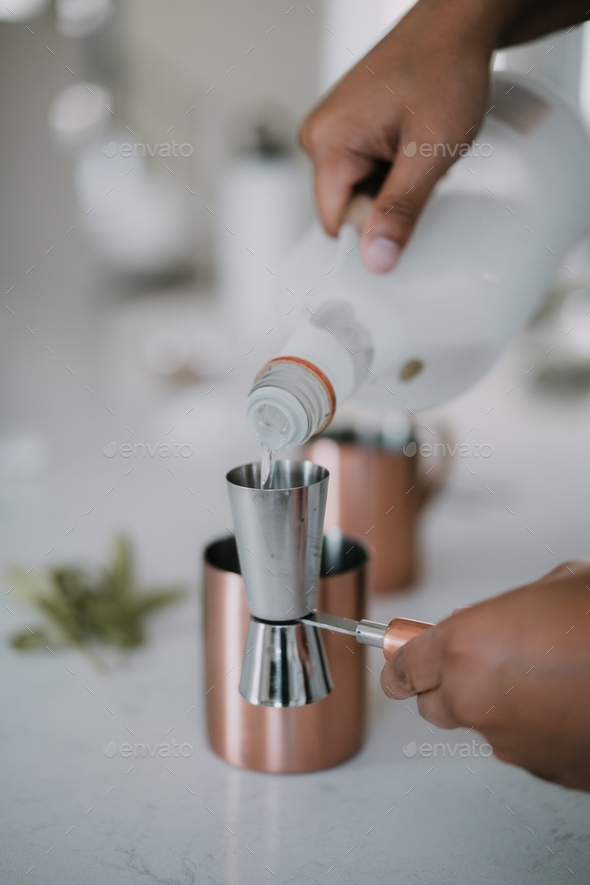 Hands making cocktail alcoholic drinks at home in kitchen white bar ...
