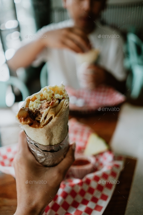 Hand holding burrito food lunch dinner first person point of view ...
