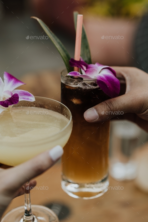 Hands holding cheers clinking glasses cocktails drink tropical flower ...