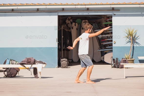 Young man surfers have fun and dance around the surfer holiday camp ...