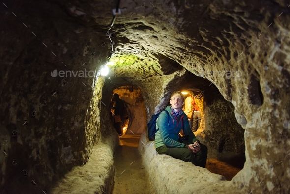 Tourist with lights exploring caves in Kaymakli ancient multi-level ...