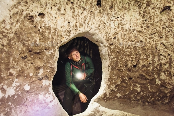 man with lights exploring caves in Derinkuyu ancient multi-level ...