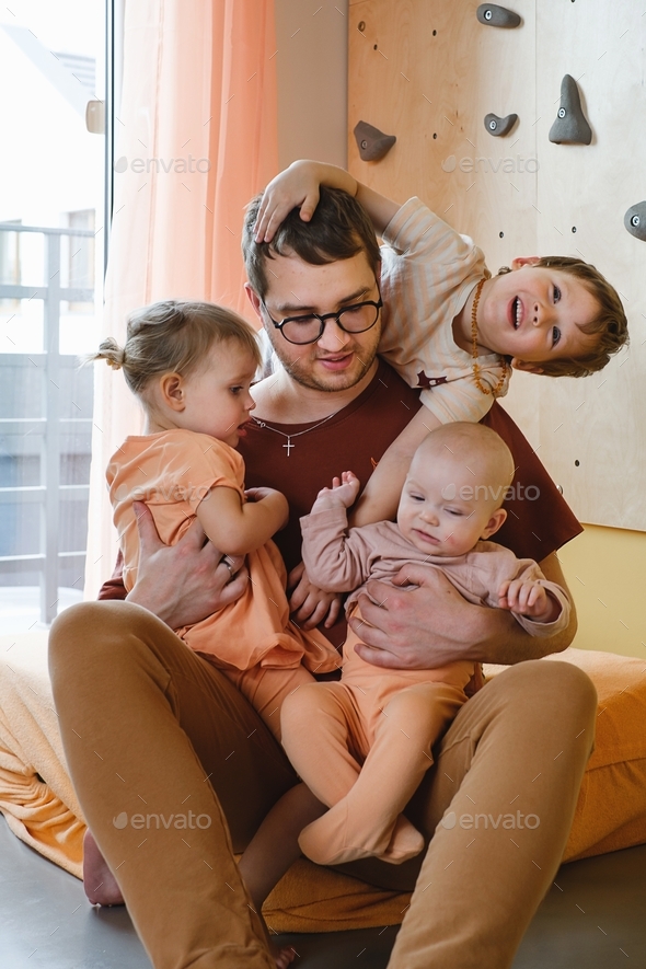Happy father of big family with tree small kids playing at home Stock ...