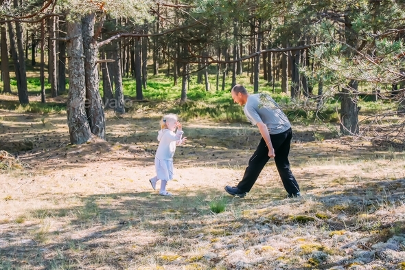 Adult man and little girl playing in a spring park. Stock Photo by ...