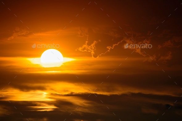 Sun glowing orb in the sky over cloud swept landscape Stock Photo by ...