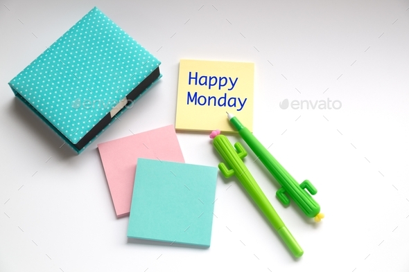 Notepad with texts say “Happy Monday” and a bunch of stationary items ...
