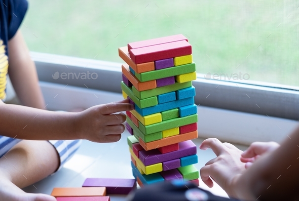Kids playing jenga at home Stock Photo by nattanartp | PhotoDune