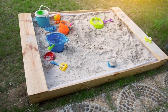 High angle view of a sand box in home garden plus some toy folk and ...