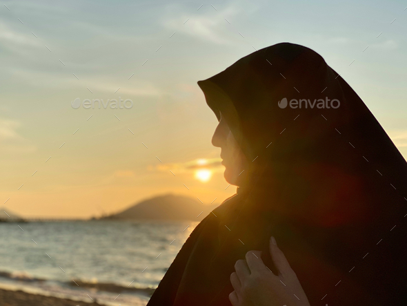Lady wearing black hijab at sunset on the beach Stock Photo by arief ...