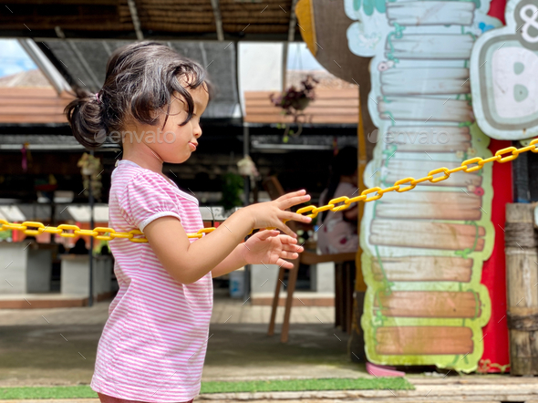 Asian little girl playing with yellow chains Stock Photo by arief ...