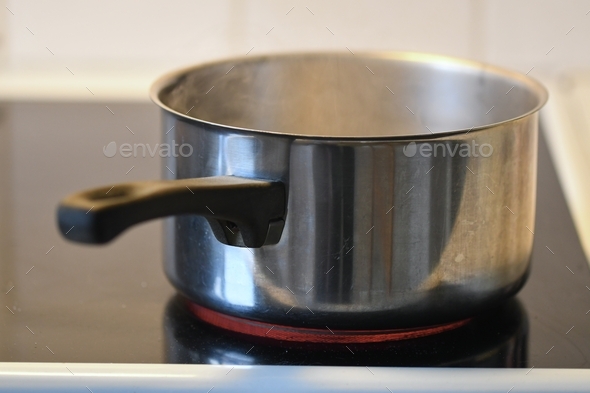 Photo of a metal pot on a stove in the kitchen Stock Photo by lindaze