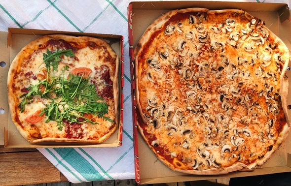 Overhead photo of two pizzas in different sizes Stock Photo by lindaze