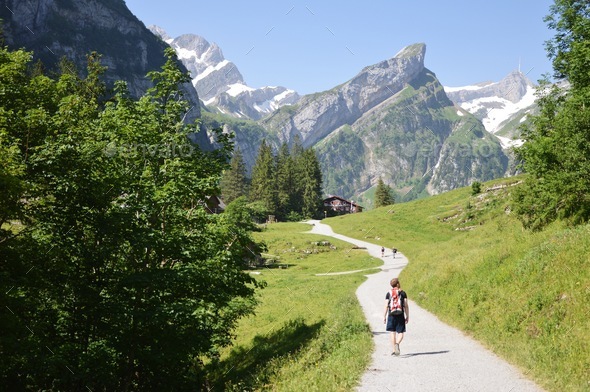 Photo of a man walking on a path in the mountains Stock Photo by lindaze