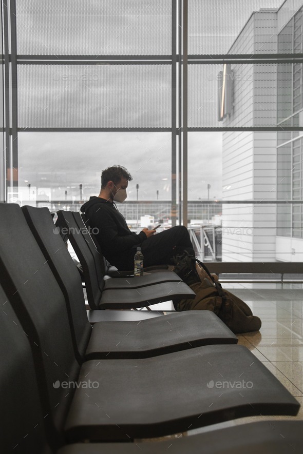 Photo of a man waiting at an airport Stock Photo by lindaze | PhotoDune